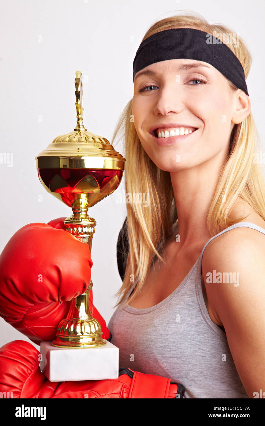 Young female boxer with red boxing gloves holding a trophy Stock Photo ...