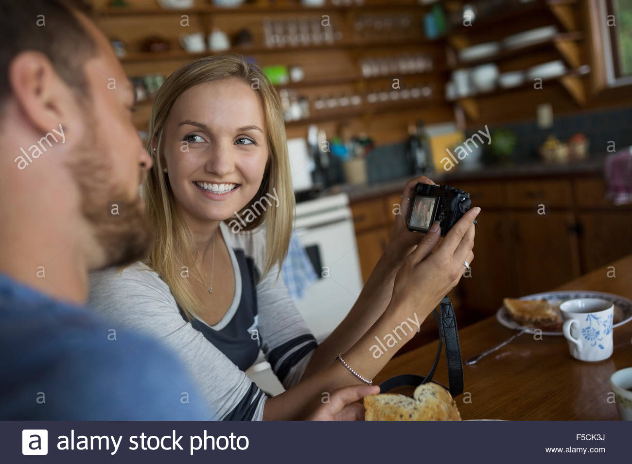Young couple viewing digital camera in kitchen Stock Photo - Alamy