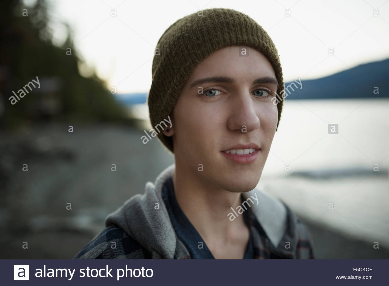 Close up portrait young man wearing beanie lakeside Stock Photo - Alamy