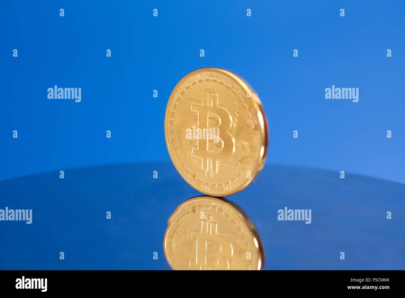 Golden Bitcoin coin on blue background Stock Photo - Alamy