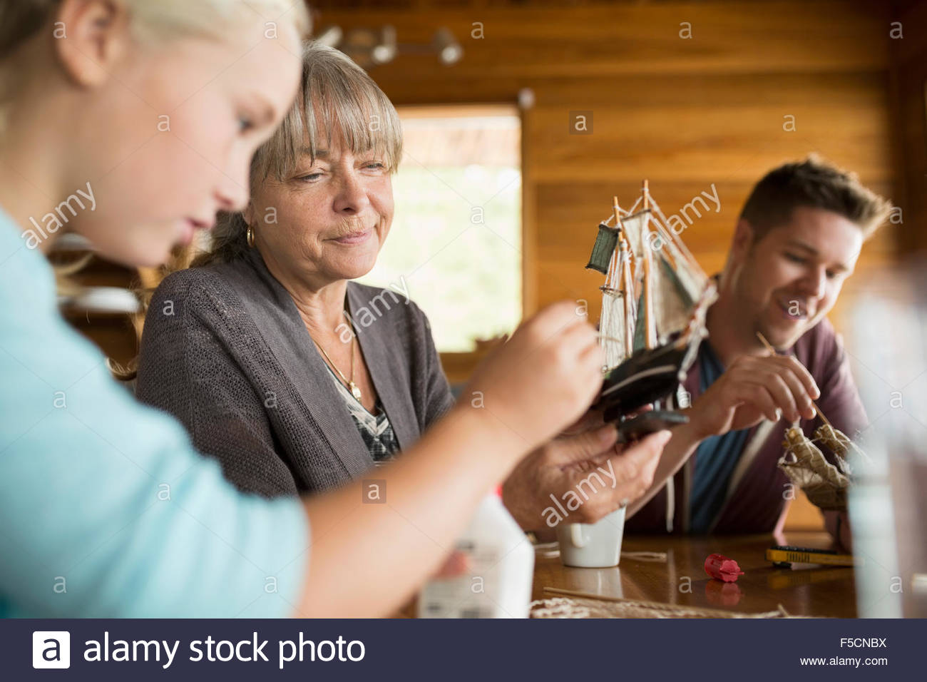 Multi-generation family assembling model ship Stock Photo - Alamy