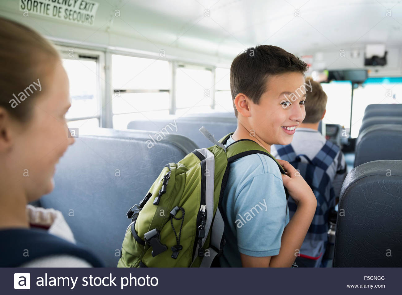 Smiling schoolboy with backpack in aisle school bus Stock Photo - Alamy