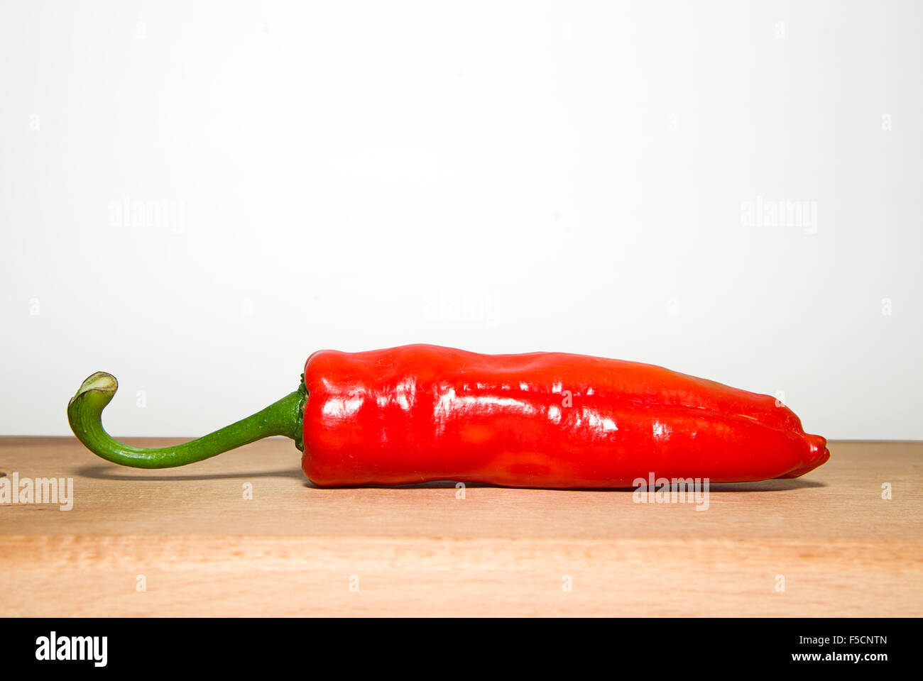 One red pepper on a white background Stock Photo - Alamy