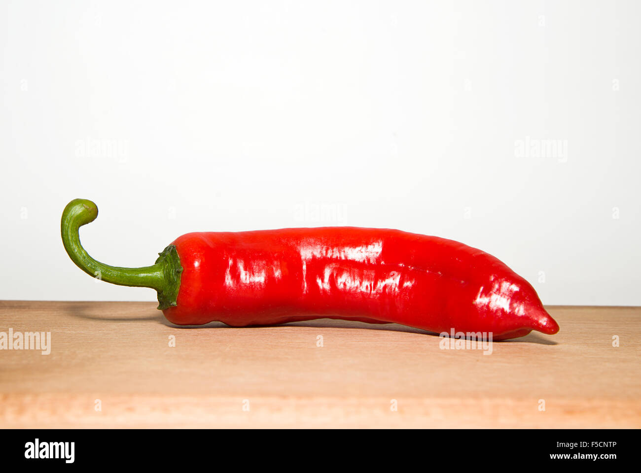 One red pepper on a white background Stock Photo - Alamy