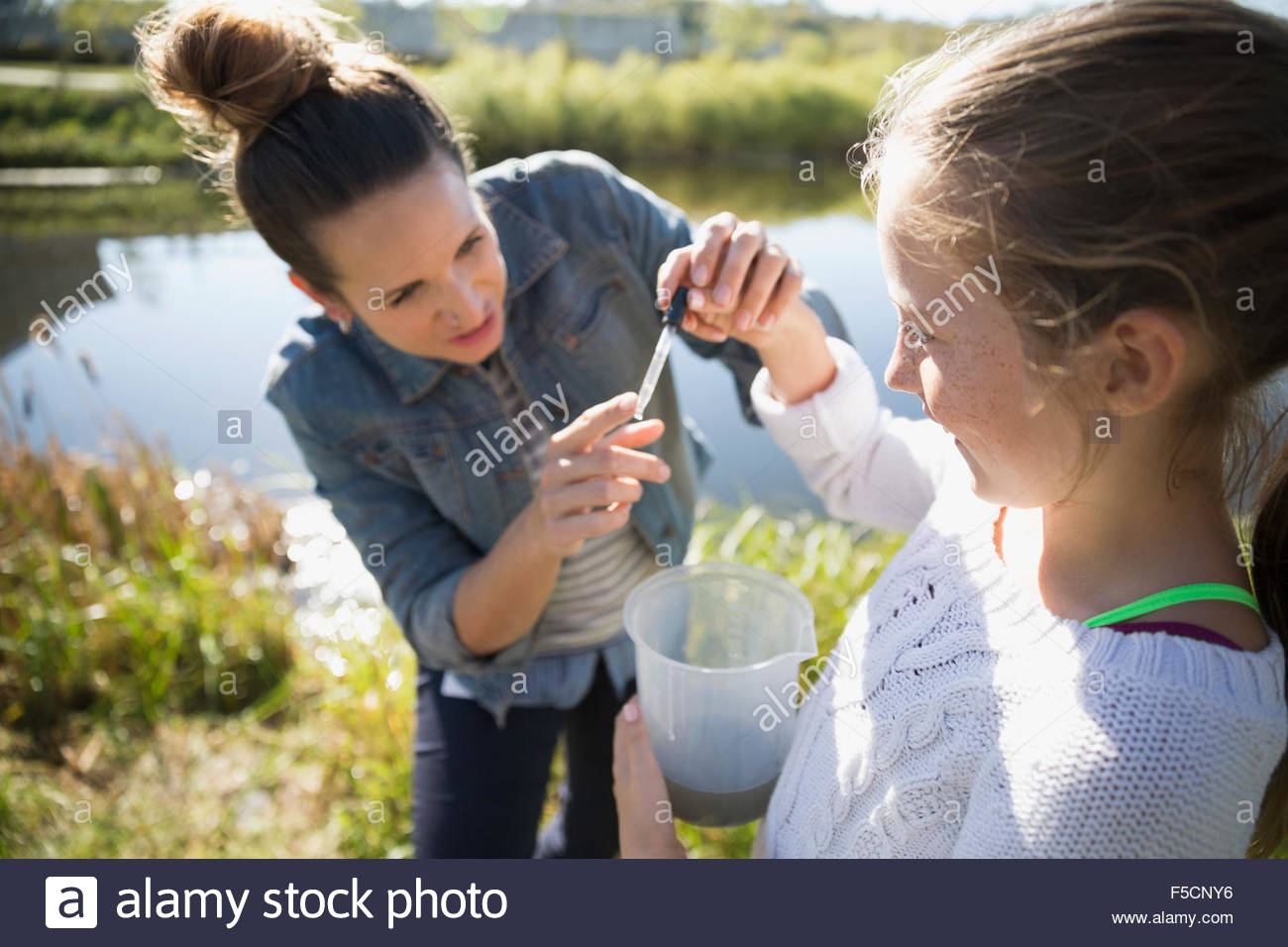 Science teacher and student testing water field trip Stock Photo - Alamy