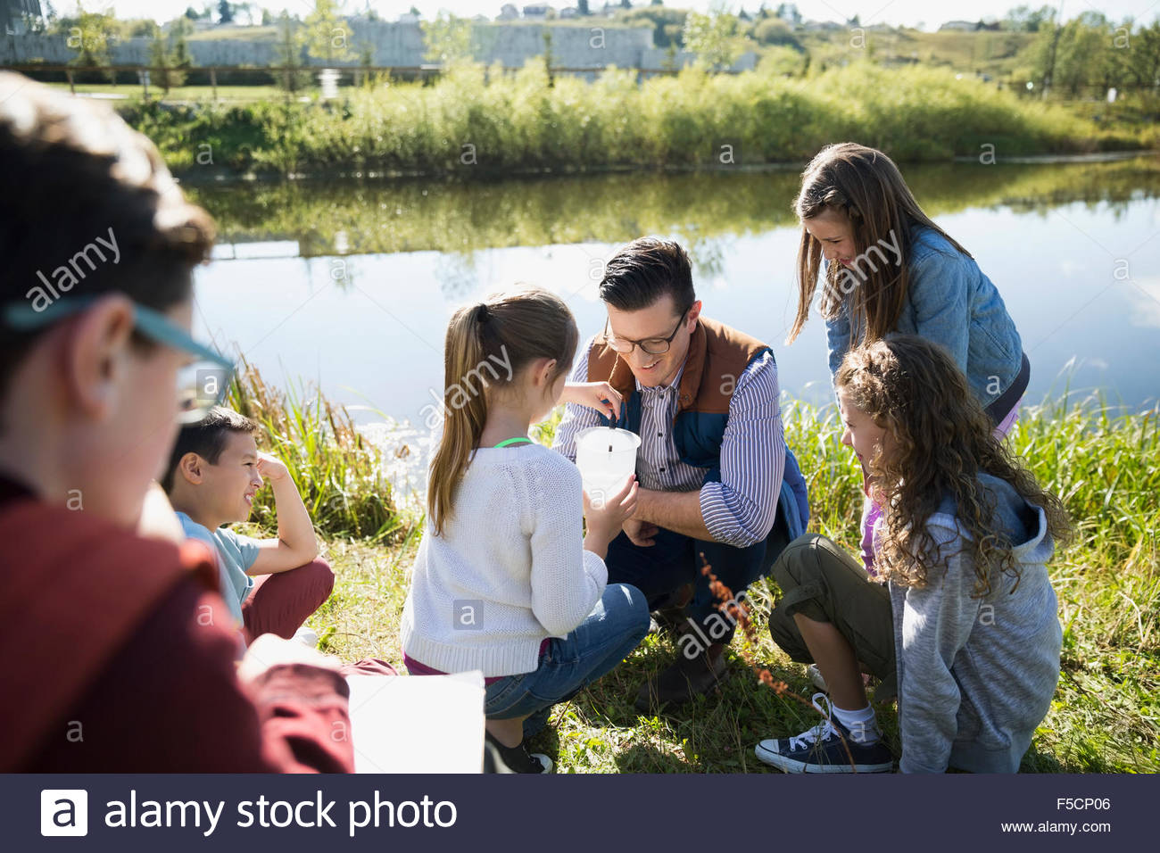 Science teacher and students testing water field trip Stock Photo - Alamy