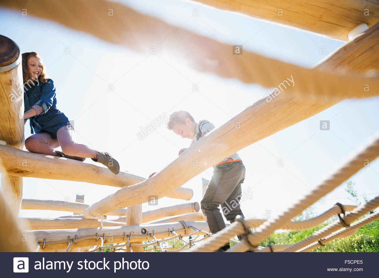 Boy and girl climbing logs sunny playground Stock Photo - Alamy