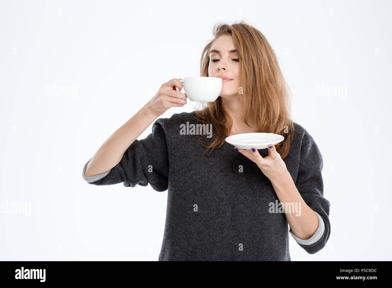 Portrait of a beautiful woman smelling cup with coffee isolated on a ...