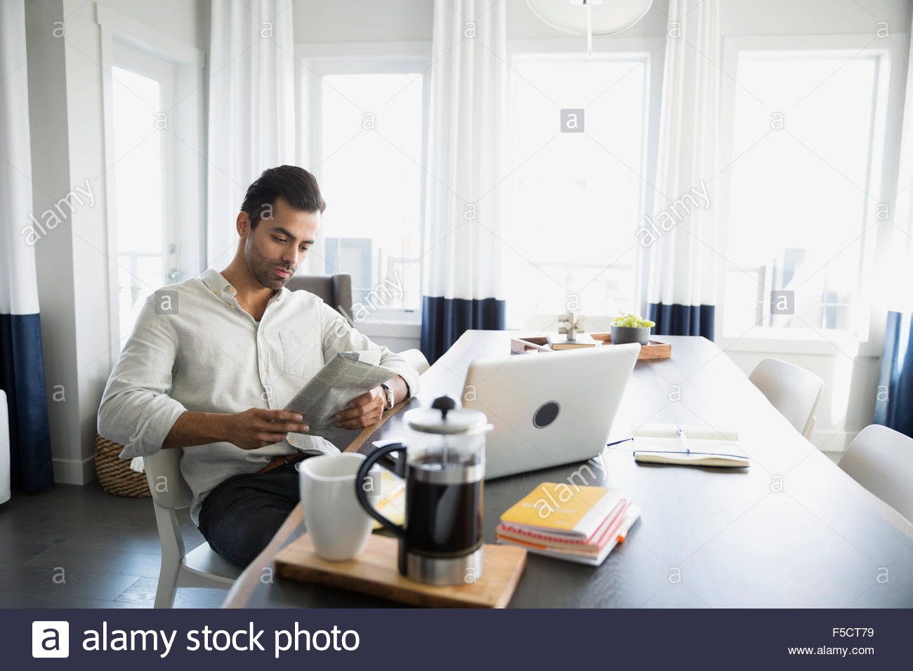 Man reading newspaper table hi-res stock photography and images - Alamy