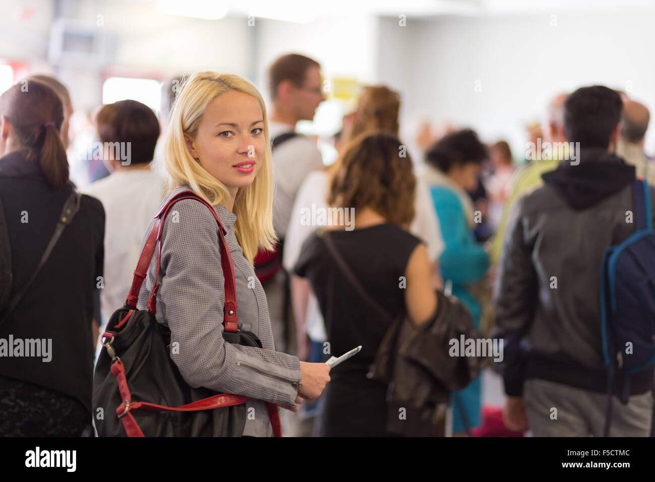 Young blond caucsian woman waiting in line Stock Photo - Alamy