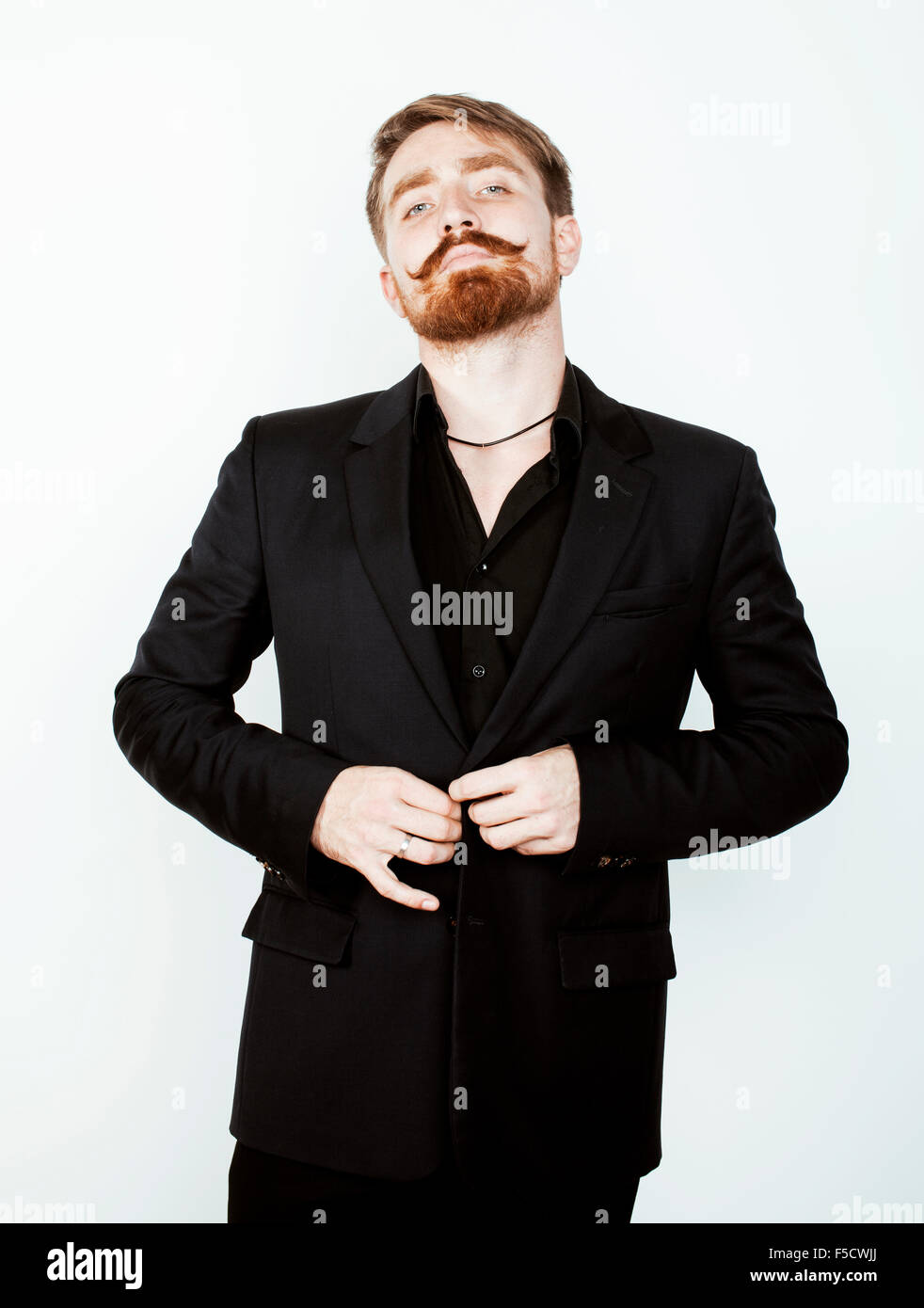 young red hair man with beard and mustache in black suit on white ...