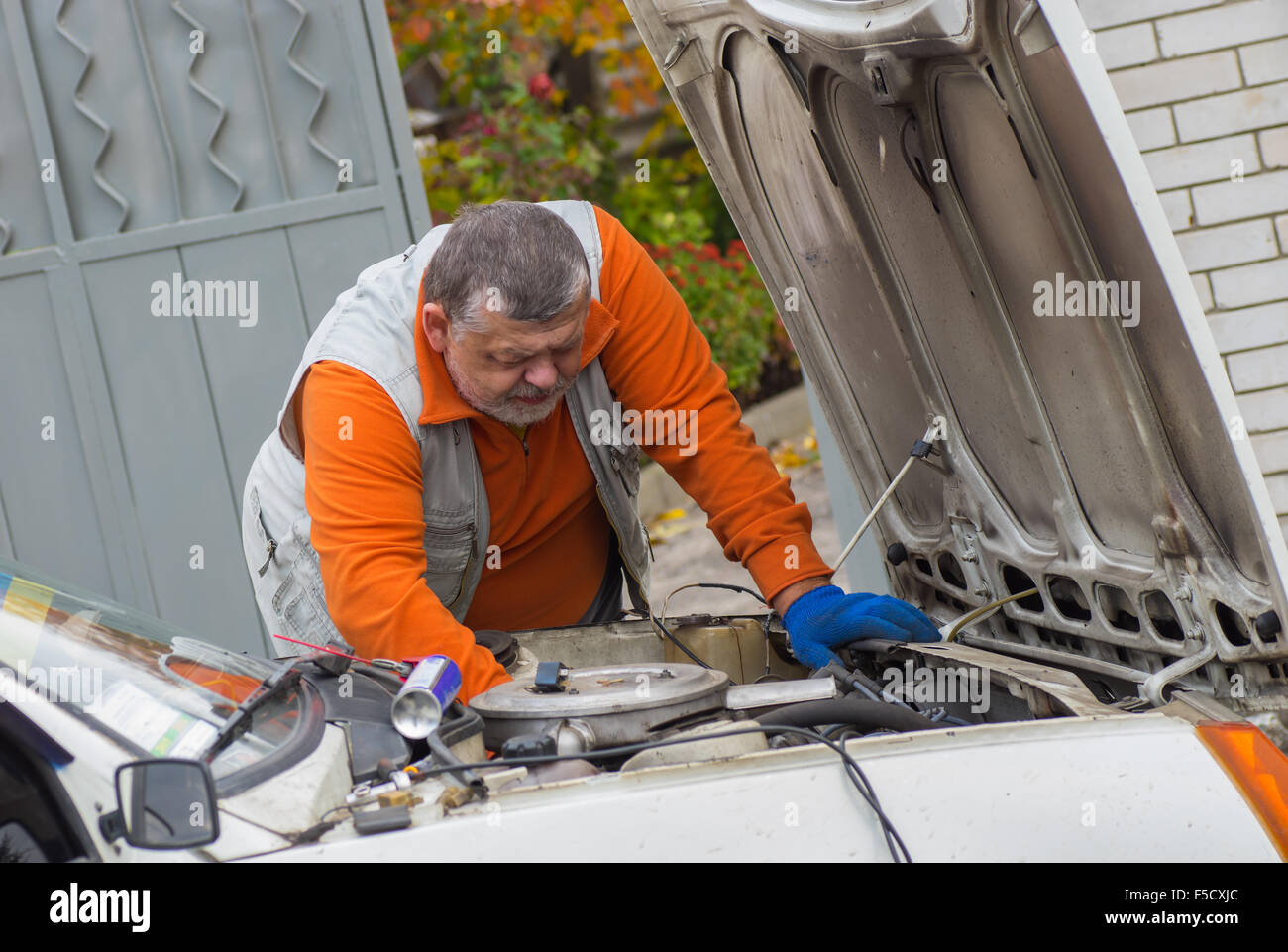 Old man doing car engine repair outdoor Stock Photo - Alamy