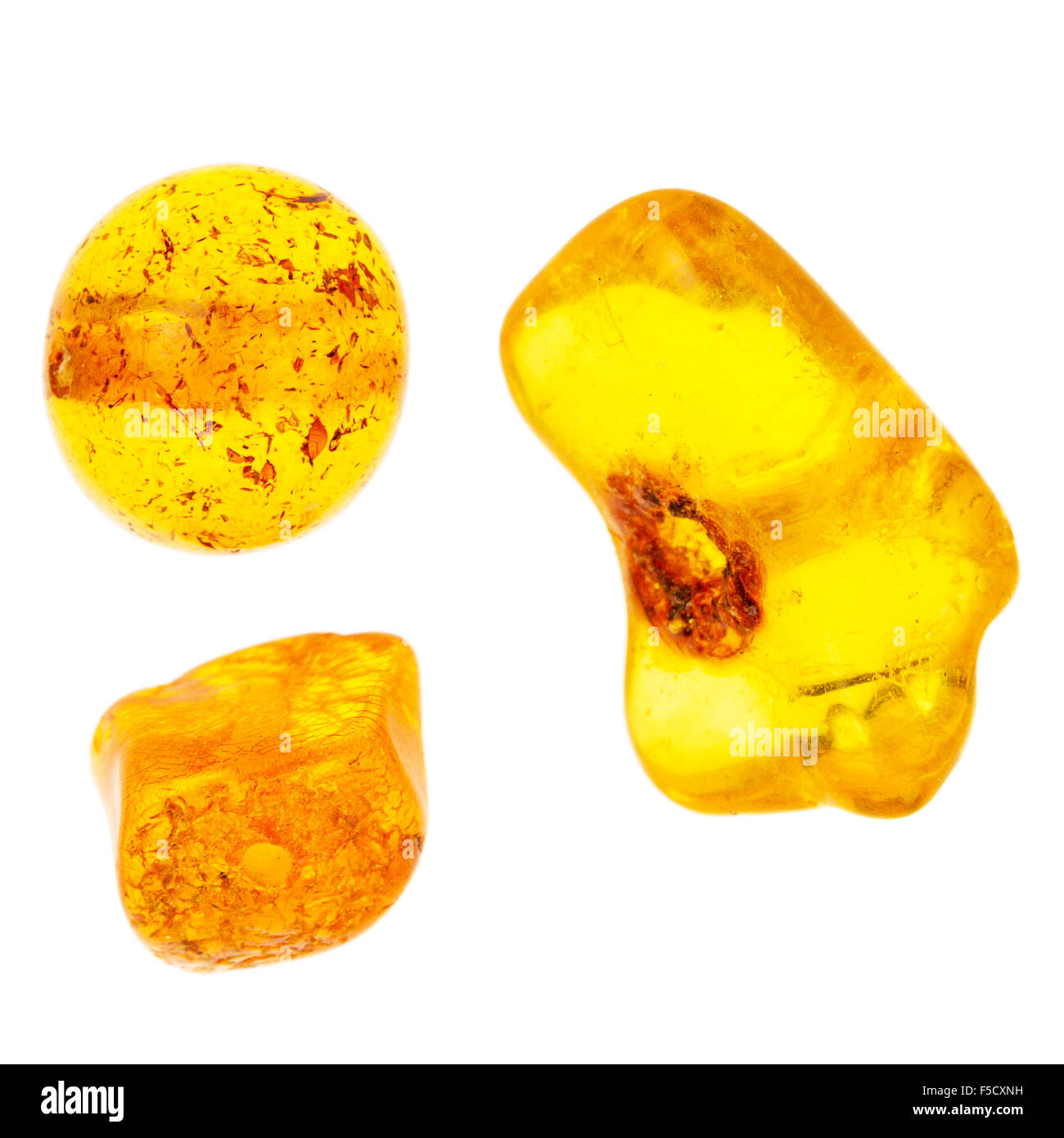 Three small amber beads isolated on white background Stock Photo - Alamy