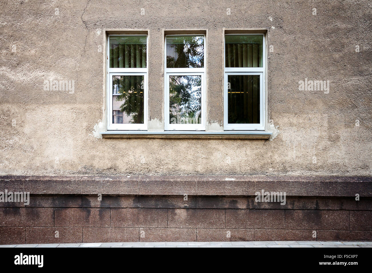 Aged weathered street wall with three windows Stock Photo - Alamy