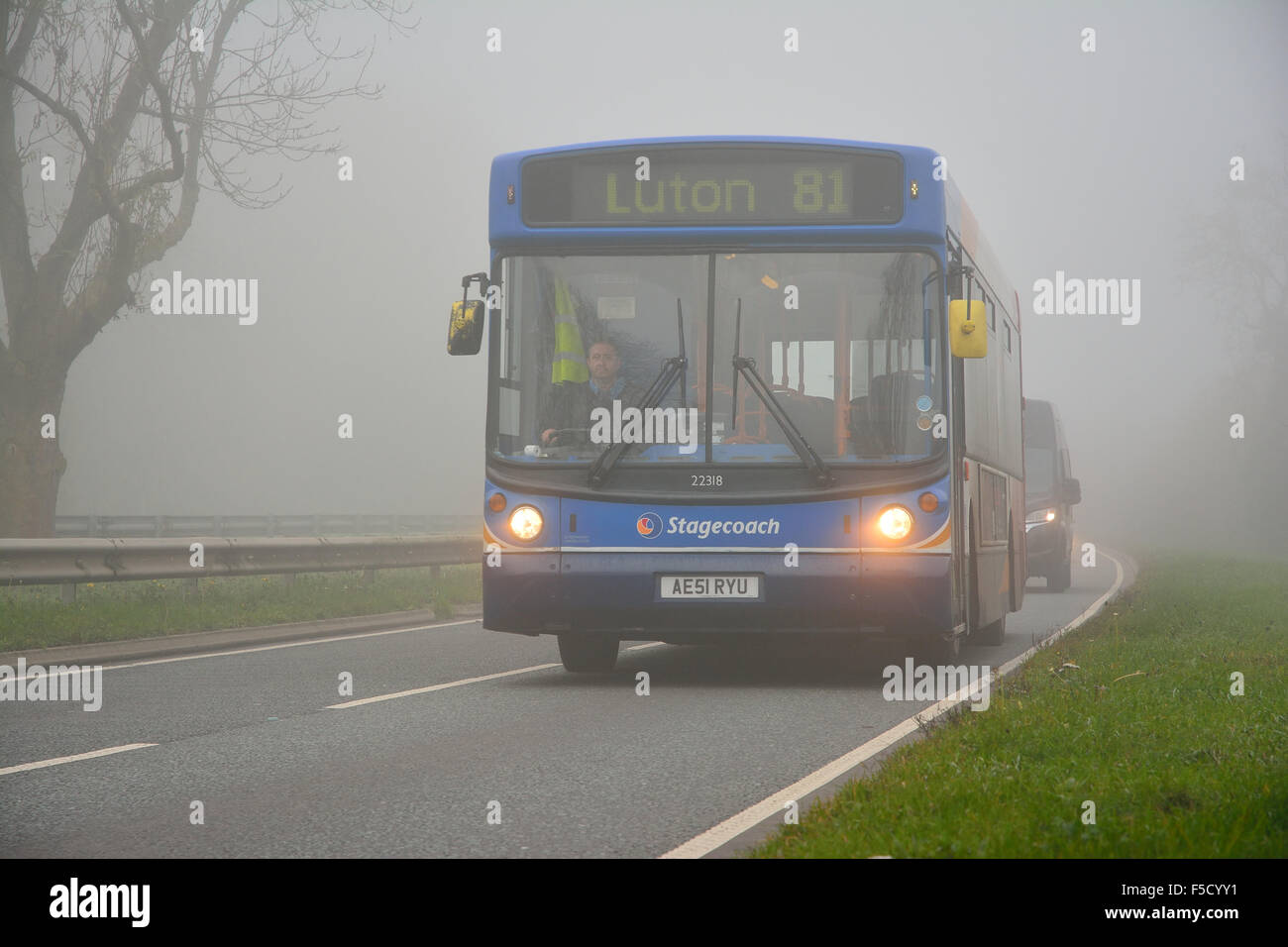 Bus driving on road through fog Stock Photo - Alamy