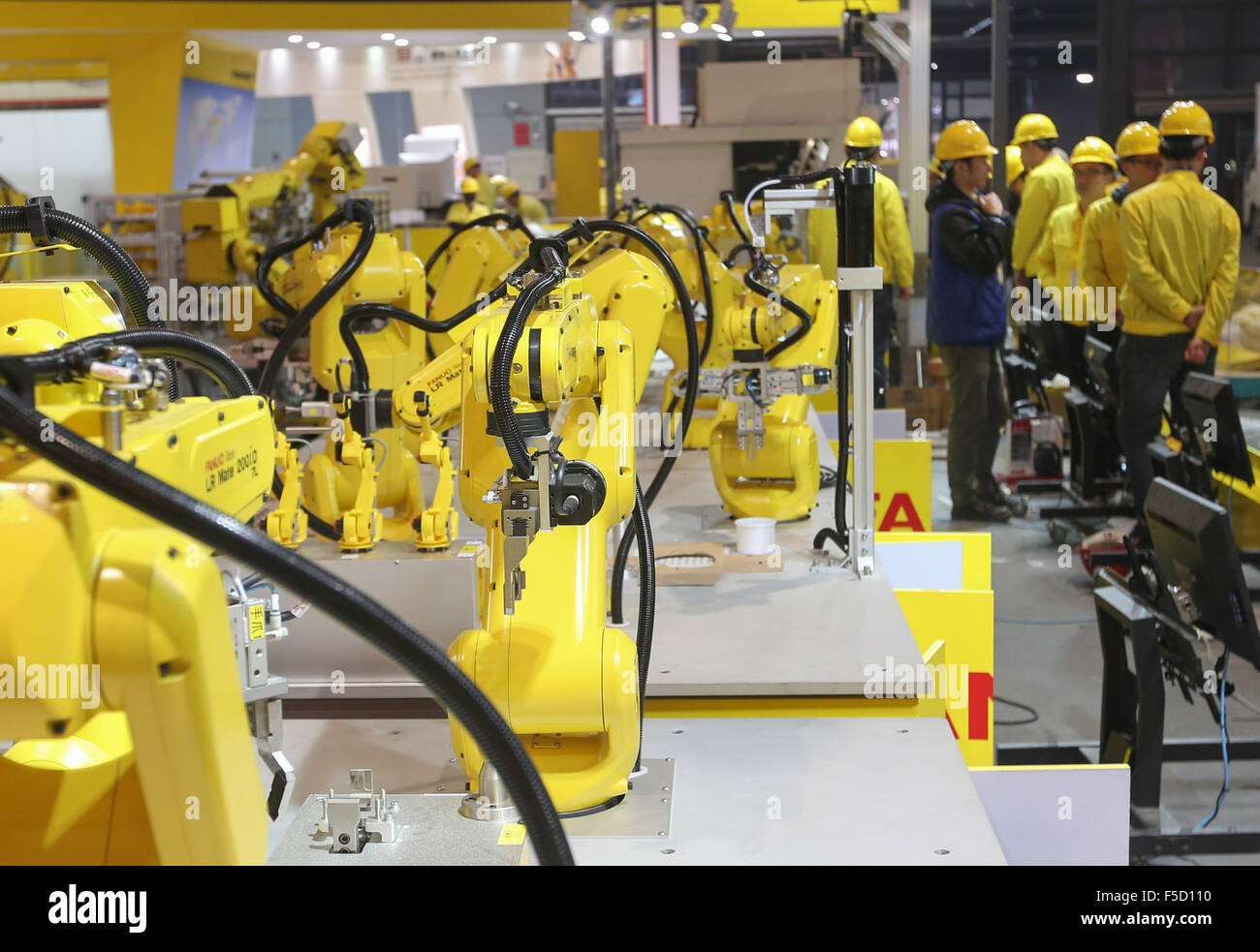 Shanghai, China. 2nd Nov, 2015. Workers arrange robots in an exhibition ...