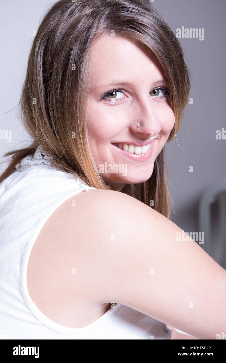 Pretty young girl on couch writing in Book Stock Photo - Alamy
