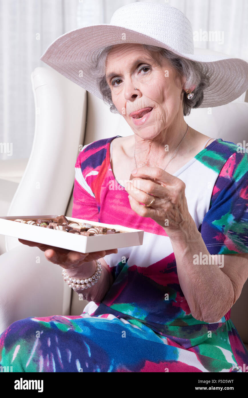active female senior earing chocolate candy Stock Photo - Alamy