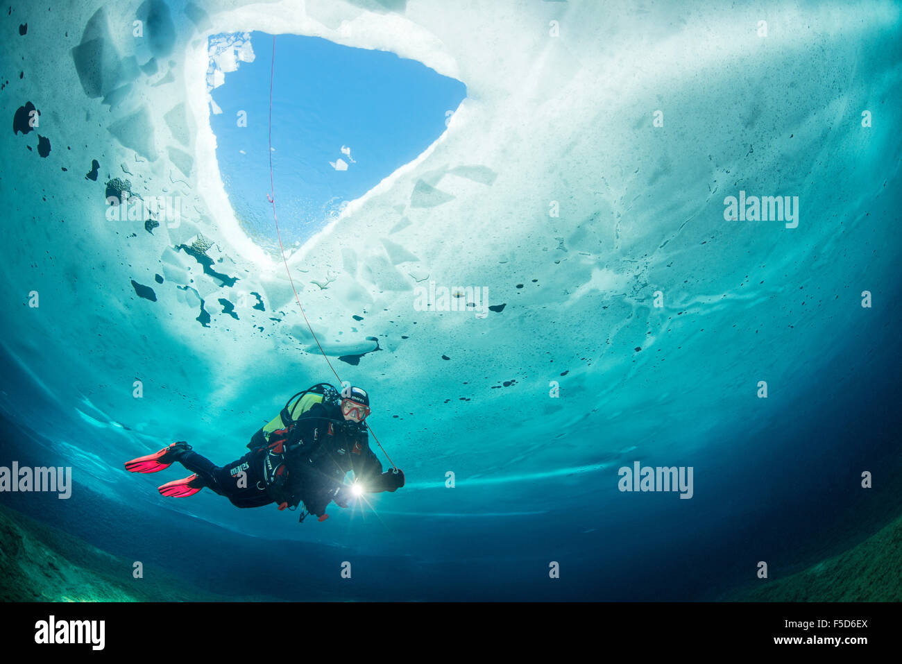 scuba diver under ice or icehole with safety robe, scuba icediving ...