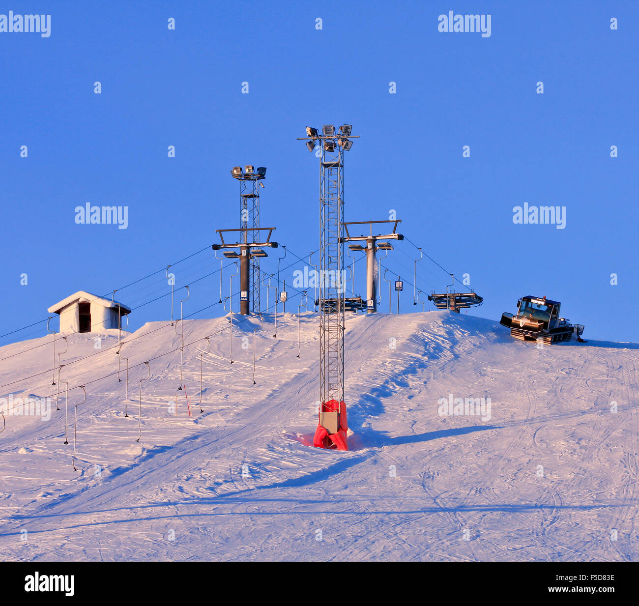 Preparing the downhill slope in the morning. Ski lift, grooming machine ...