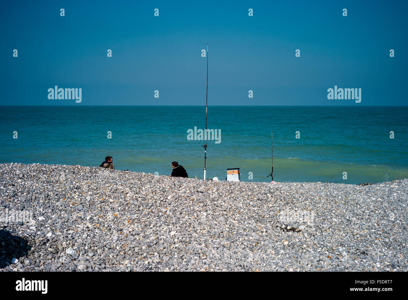 Two men sit beach fishing on the Channel coast, Normandy, France Stock ...