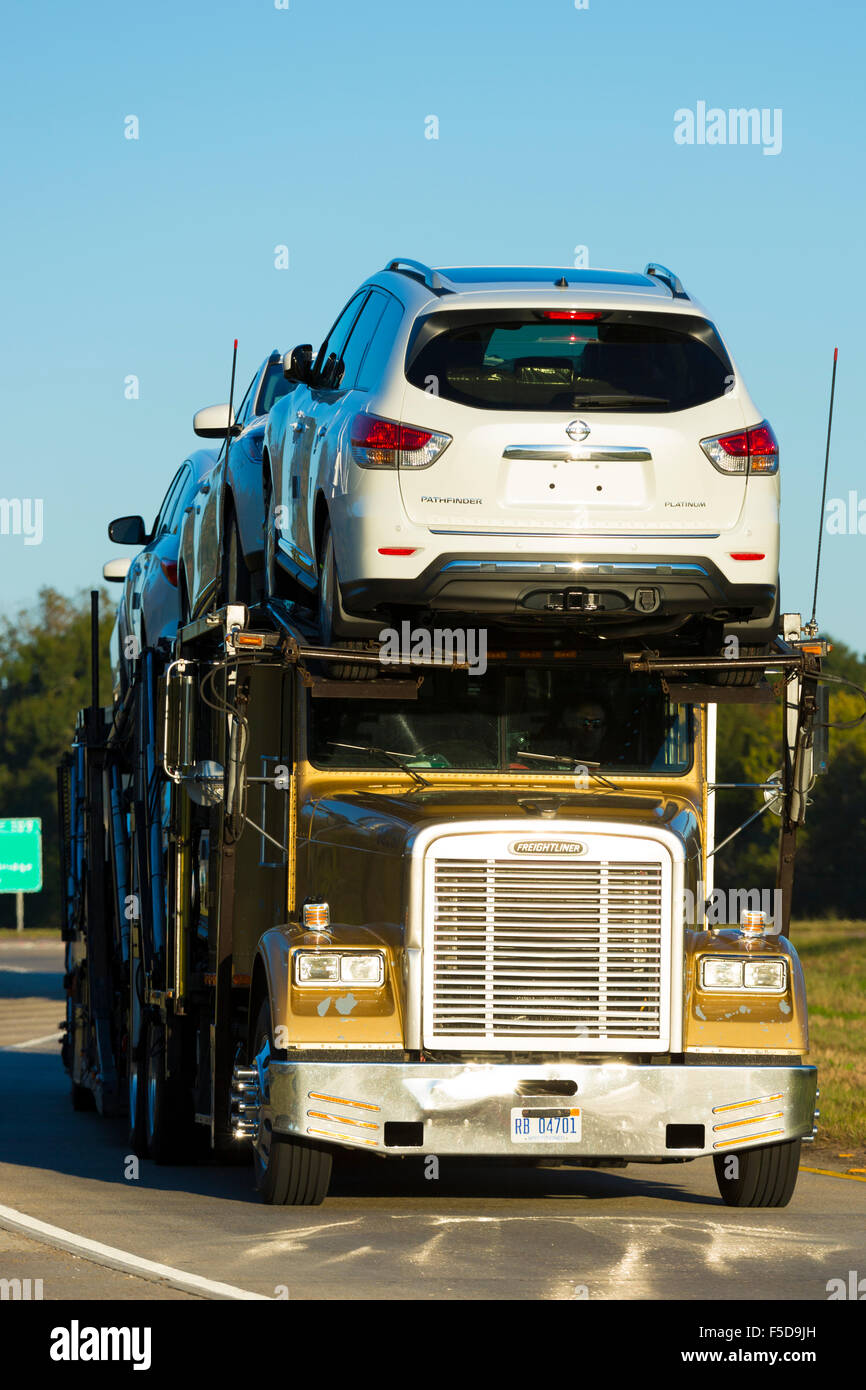 Typical shiny American Freightliner truck transporting new automobiles ...
