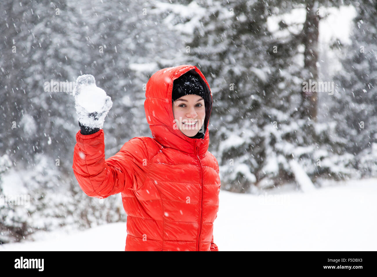 Pretty young woman playing snowballs Stock Photo - Alamy