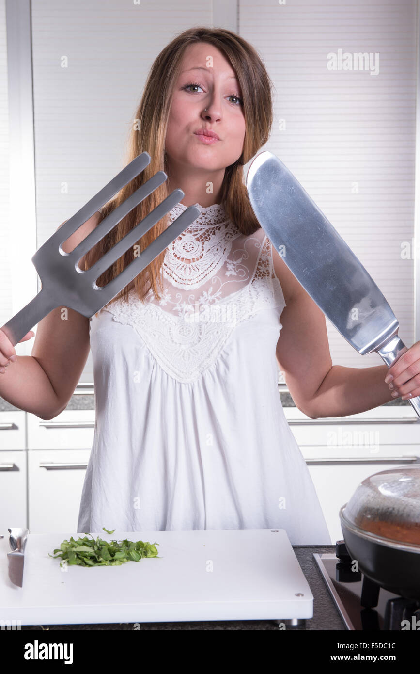 attractive young woman with big fork and knife Stock Photo - Alamy