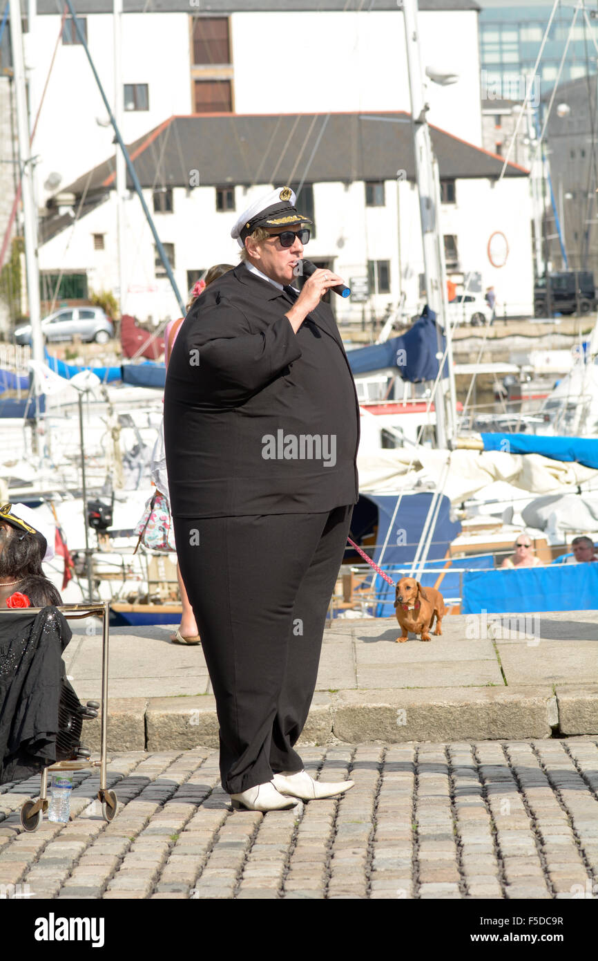 Street Performer dressed in inflated ships captain uniform on docks at ...