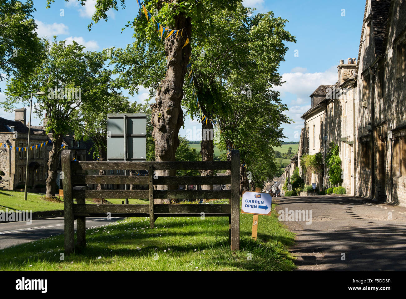 A bench at the top of the High Street next to an Open Gardens sign to a ...