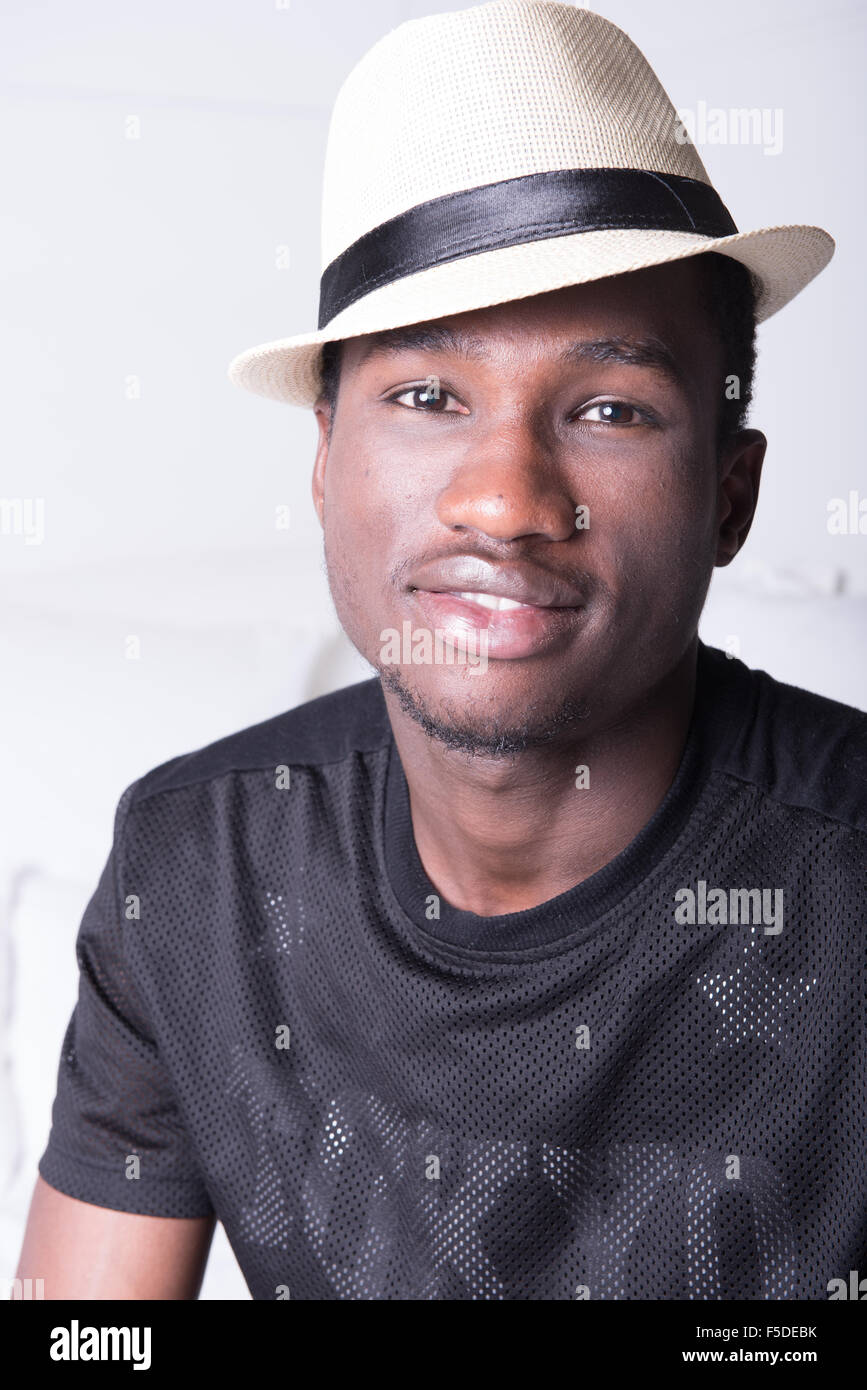 african man with hat sitting on couch Stock Photo - Alamy