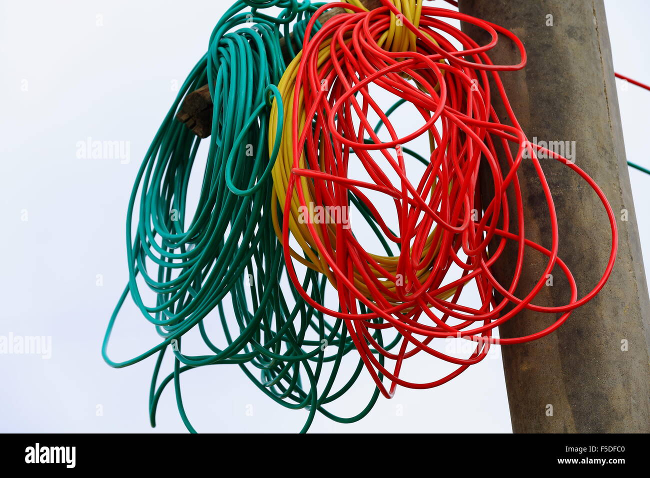 Tangled colorist electrical wires set on an utility pole on a street of ...