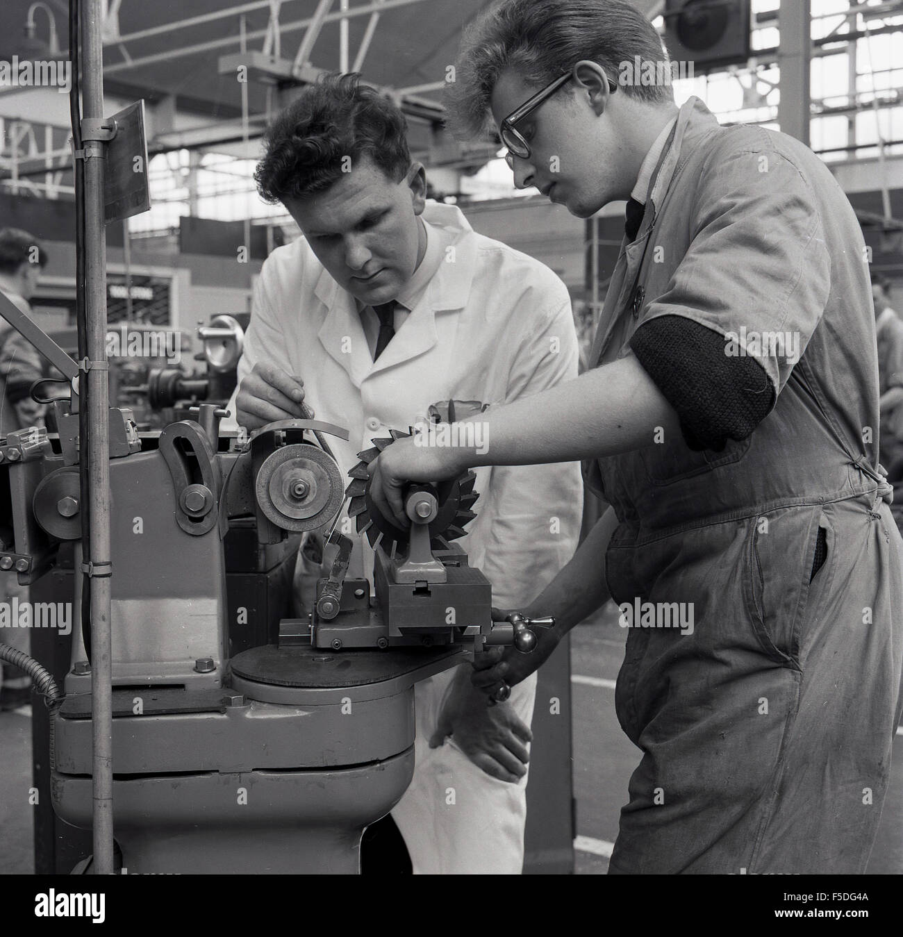 1950s historical, white coated engineer showing young male aviation ...