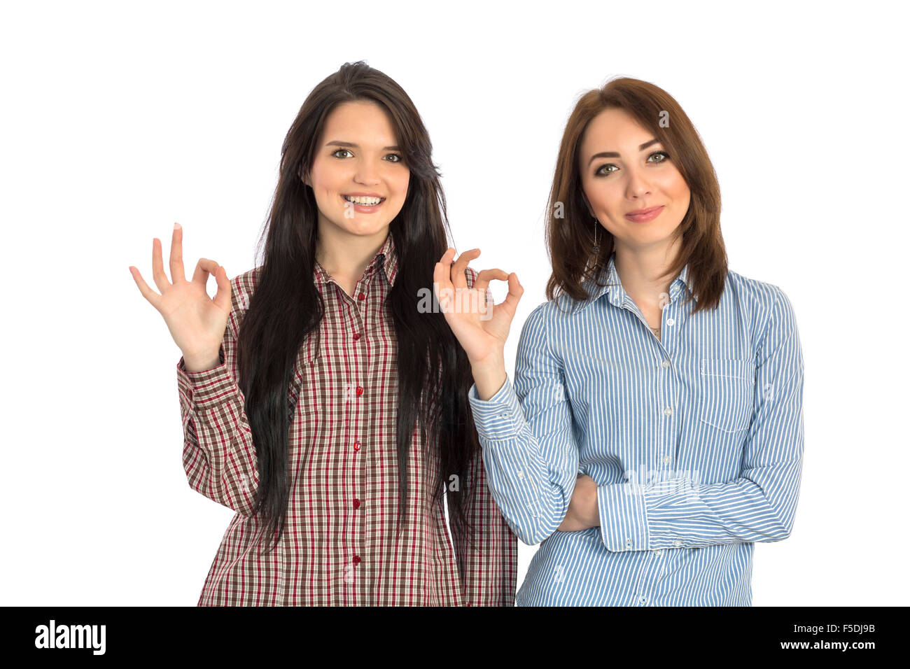 Two cheerful girls makes OK hand sign Stock Photo - Alamy