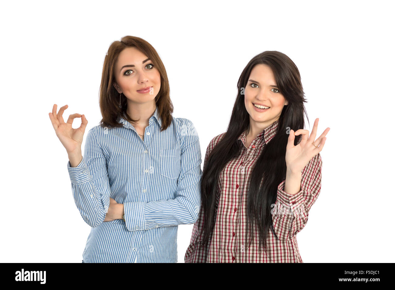 Two cheerful girls makes OK hand sign Stock Photo - Alamy