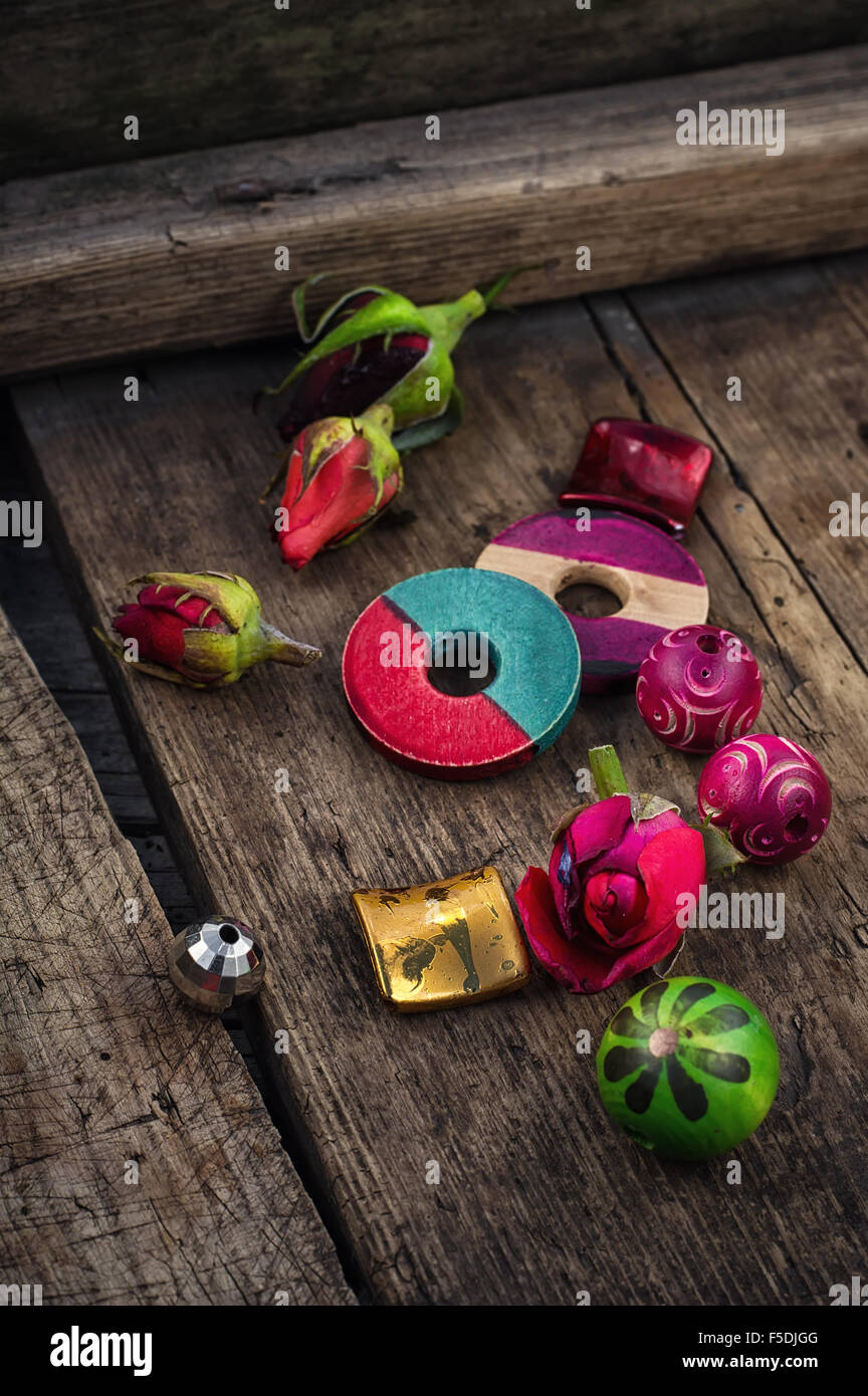 Beads,thread on background of rosebuds on the board in vintage style ...