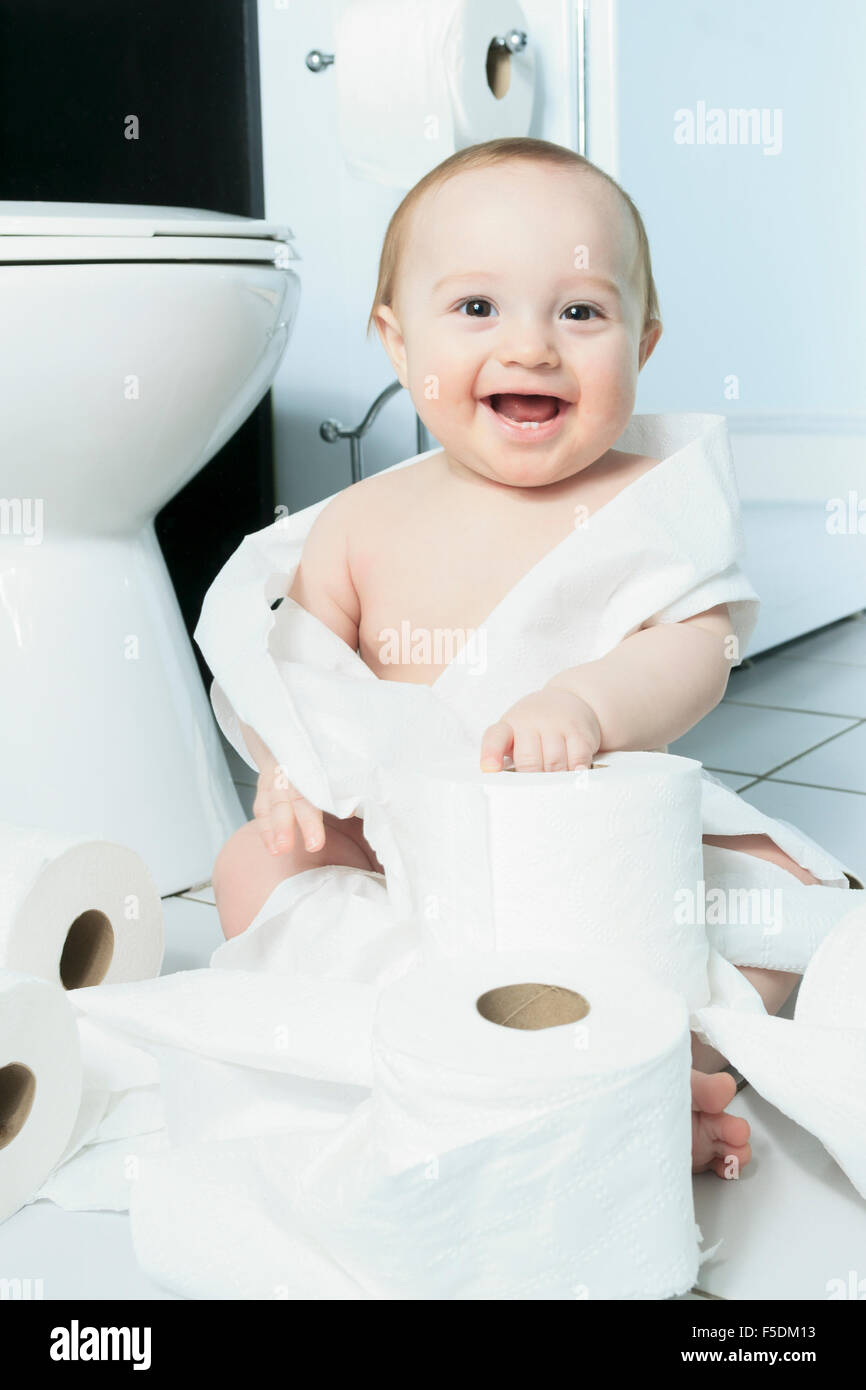Toddler ripping up toilet paper in bathroom Stock Photo - Alamy