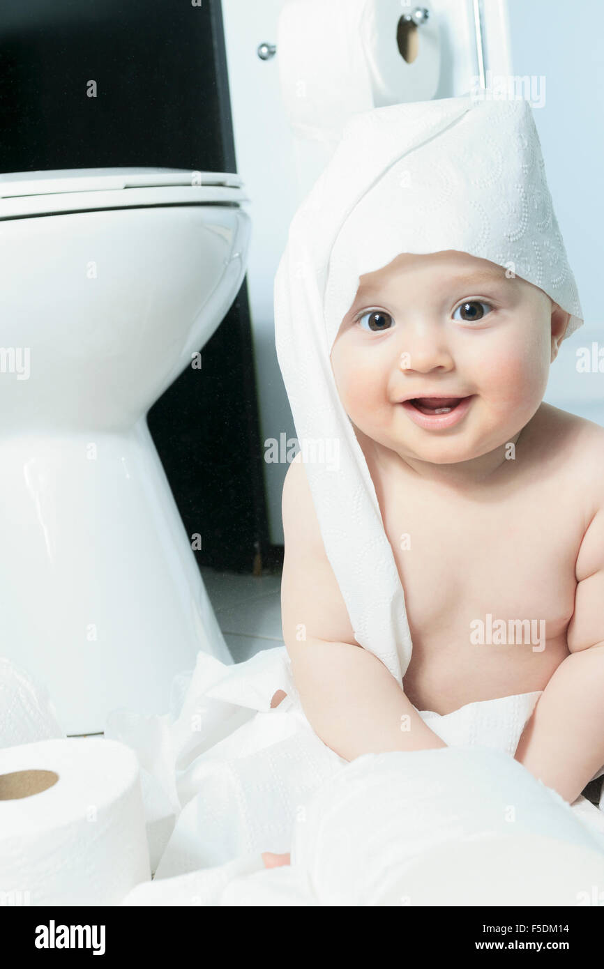 Toddler ripping up toilet paper in bathroom Stock Photo - Alamy