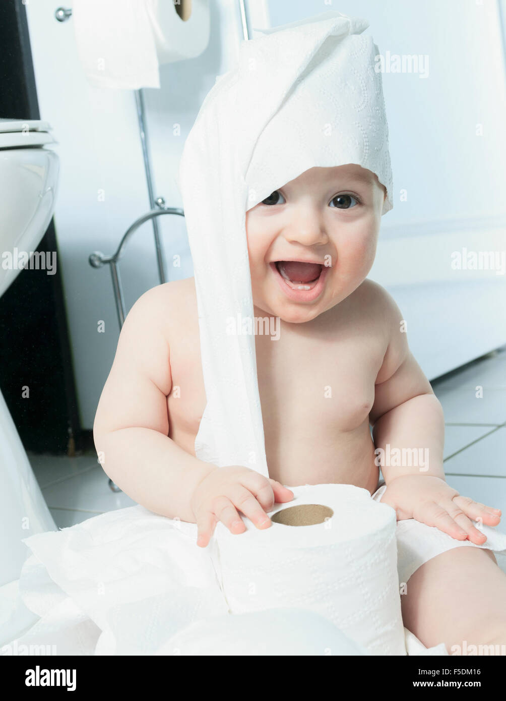Toddler ripping up toilet paper in bathroom Stock Photo - Alamy