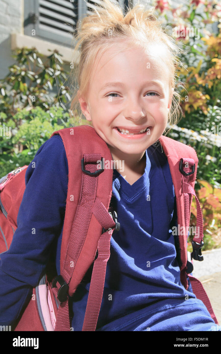 Happy little girl outside with backpack Stock Photo - Alamy