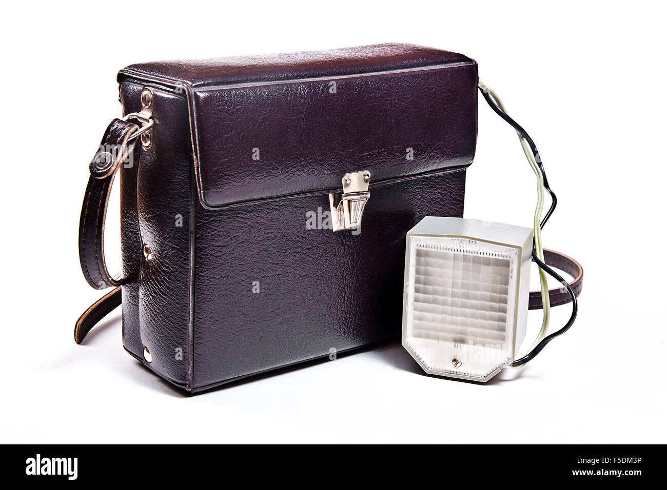 Old camera flash with a brown leather case isolated on a white ...