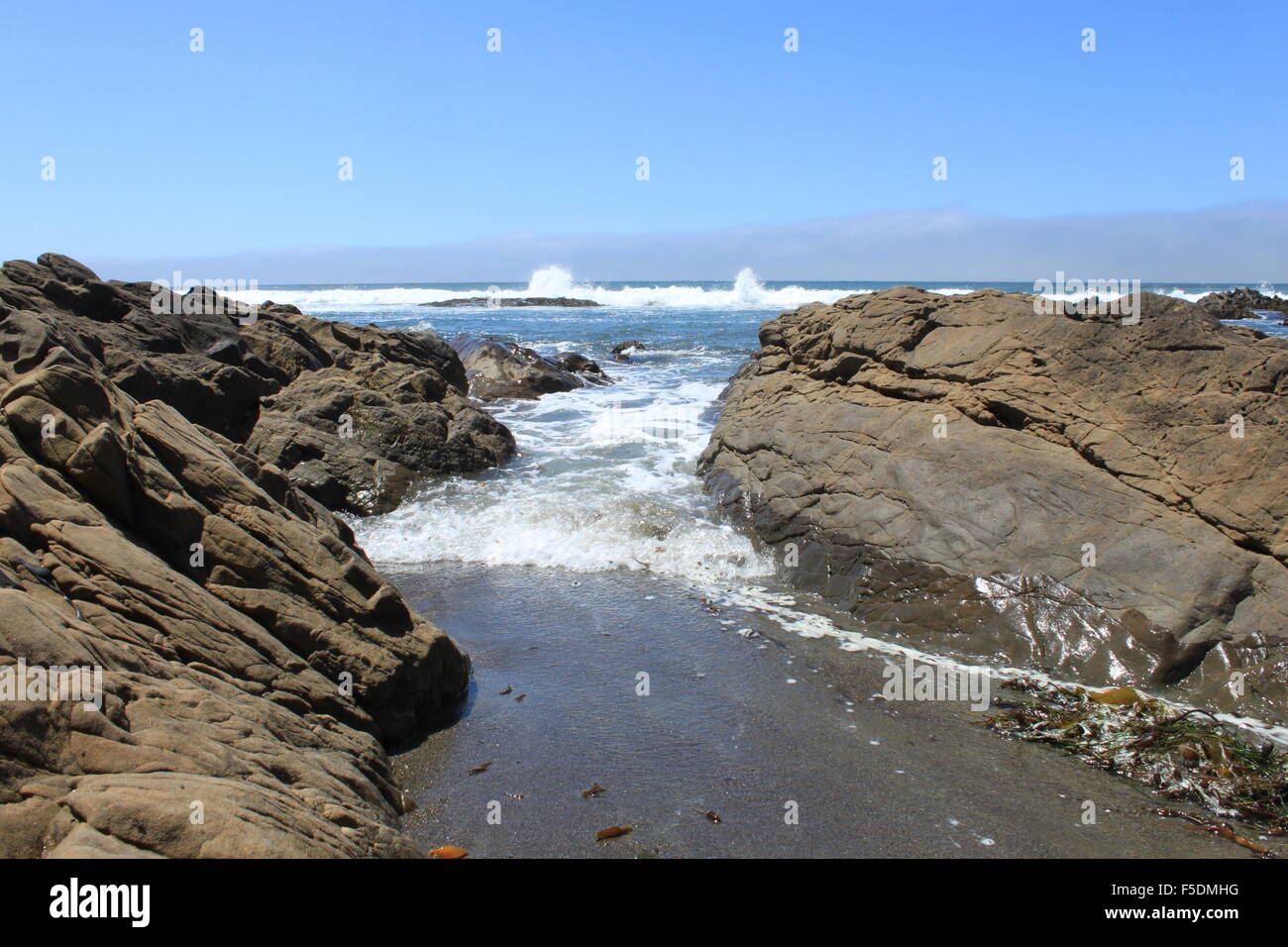 Waves coming in between the rocks . Waves crashing on the rocks ...