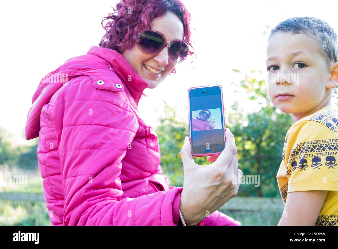 Mother and son using technology mobile cell phone to take their own ...
