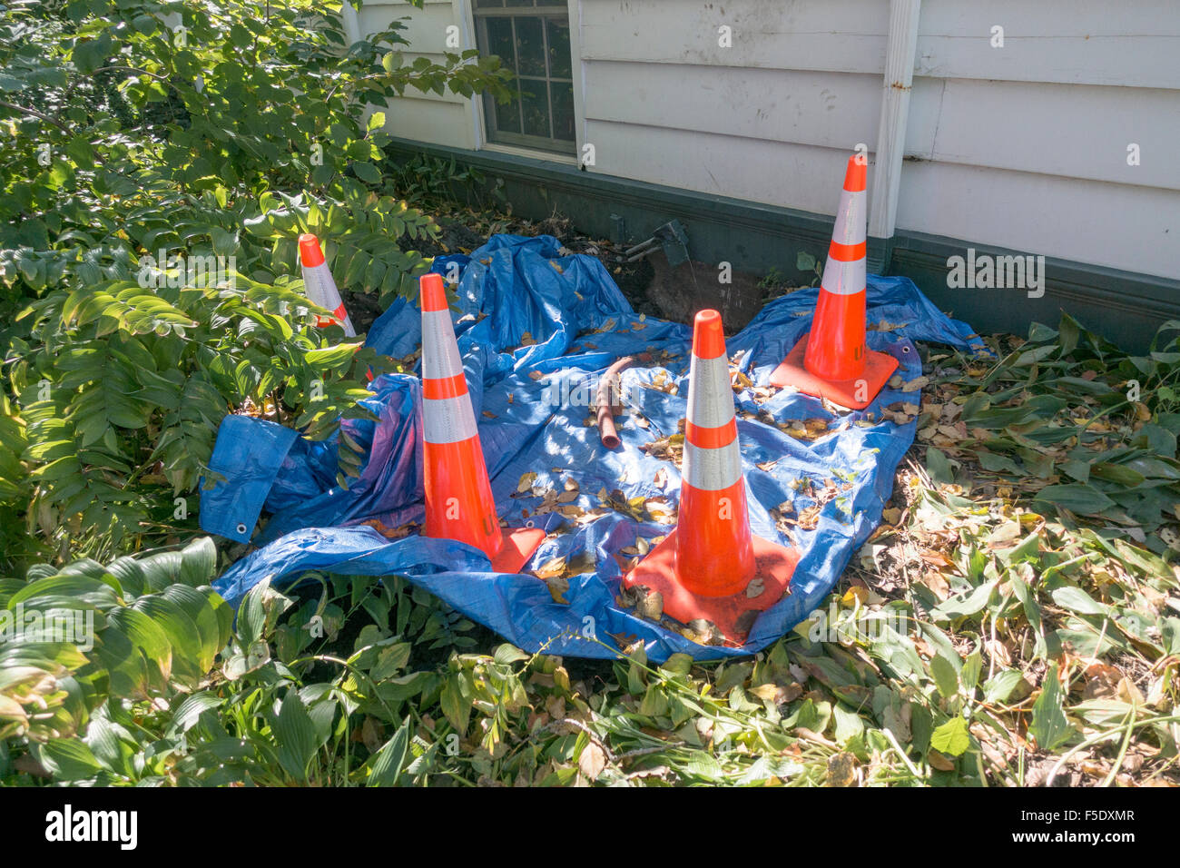 Construction site covered with blue tarp and orange and white striped ...