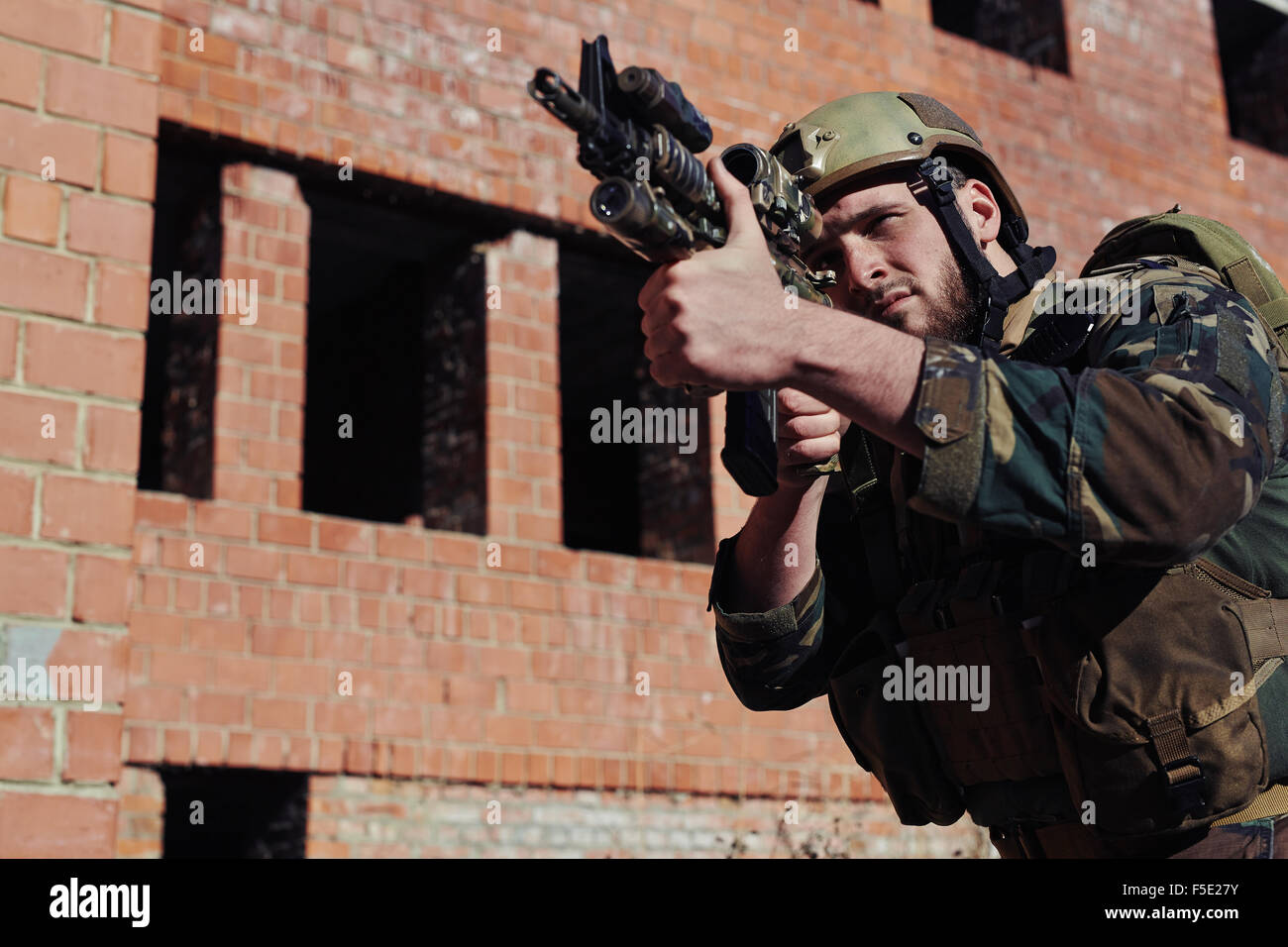 Armed soldier shooting from rifle outdoors Stock Photo - Alamy