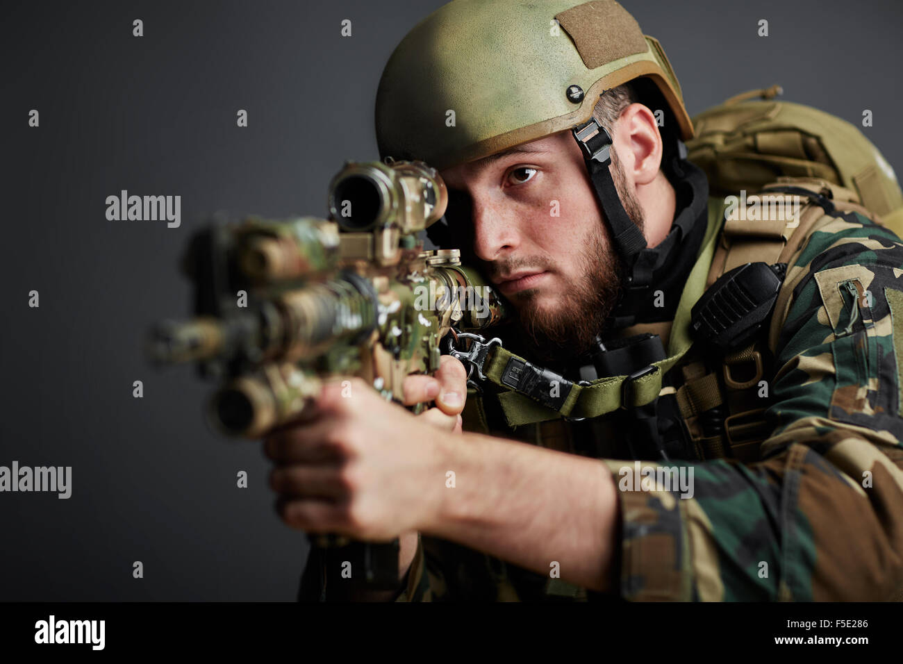 Young soldier with ammunition shooting from rifle Stock Photo - Alamy