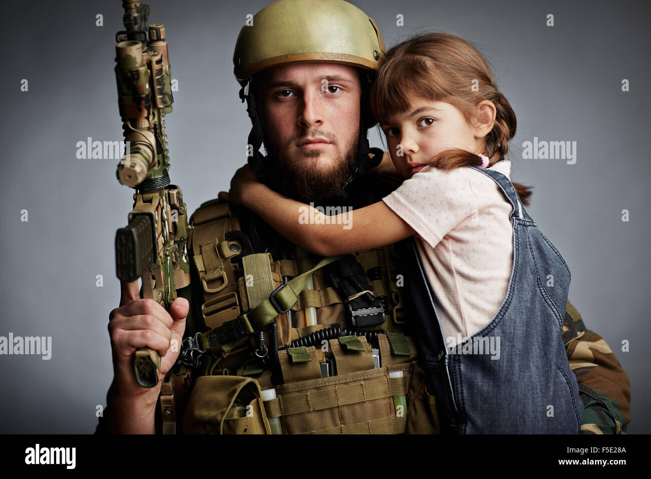 Young warrior in camouflage holding gun and little girl Stock Photo - Alamy