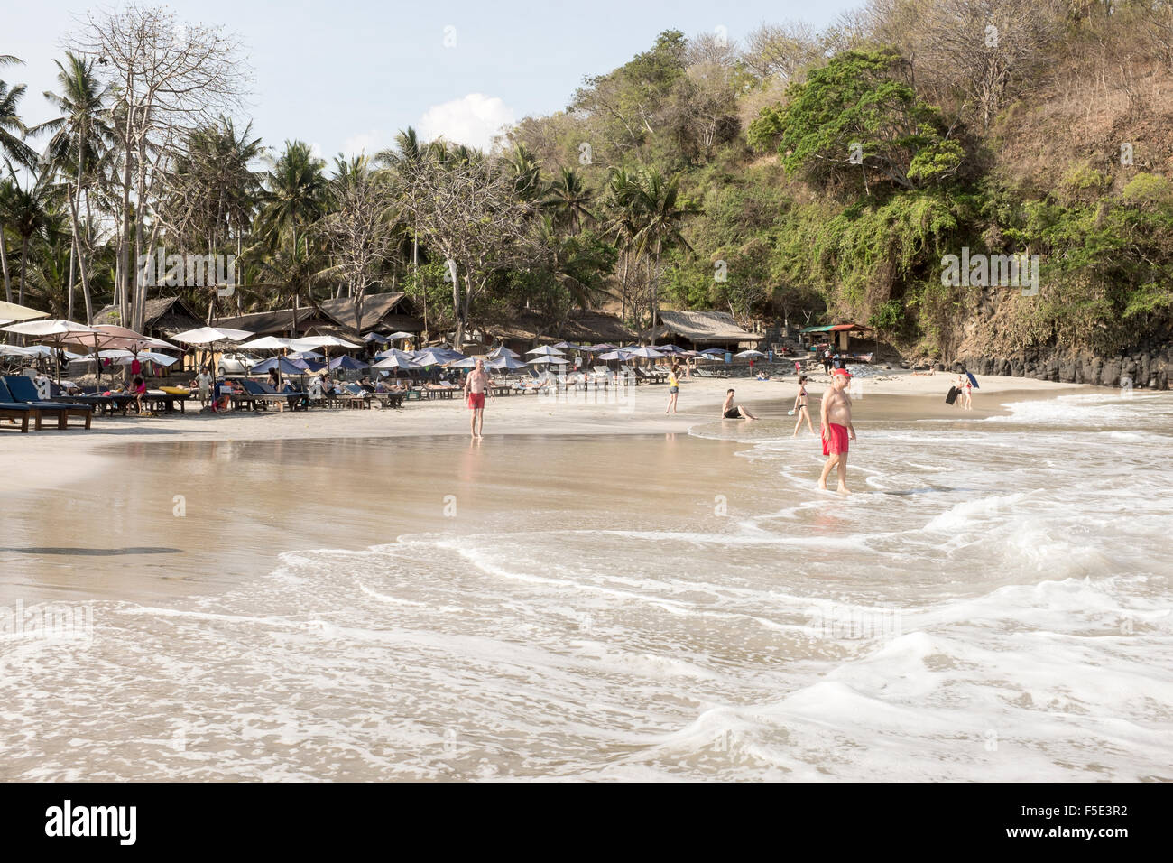 People enter the water at Pasir Putih, or White Sand beach, in Bali ...