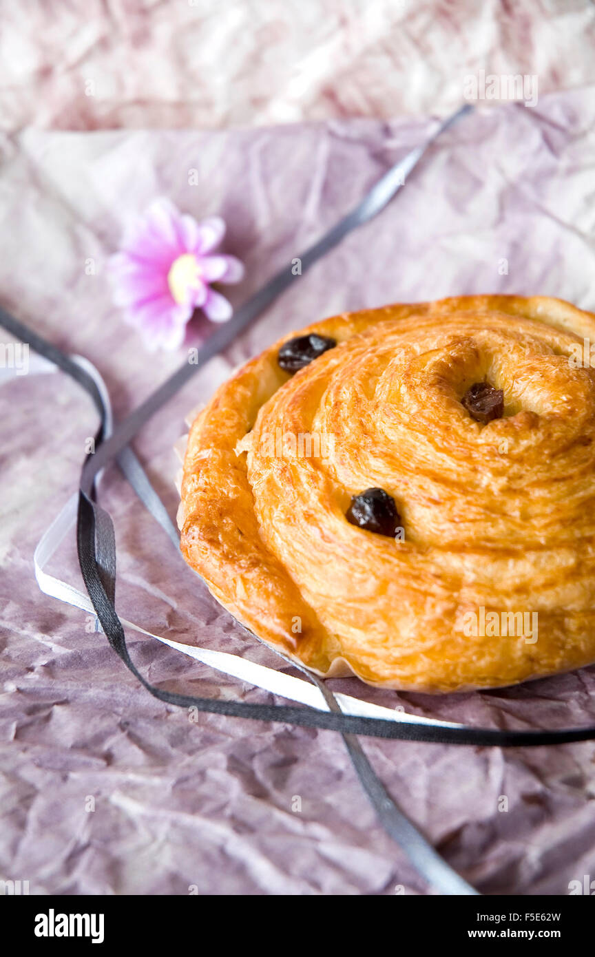 danish roll with raisin on violet background and ribbon Stock Photo - Alamy