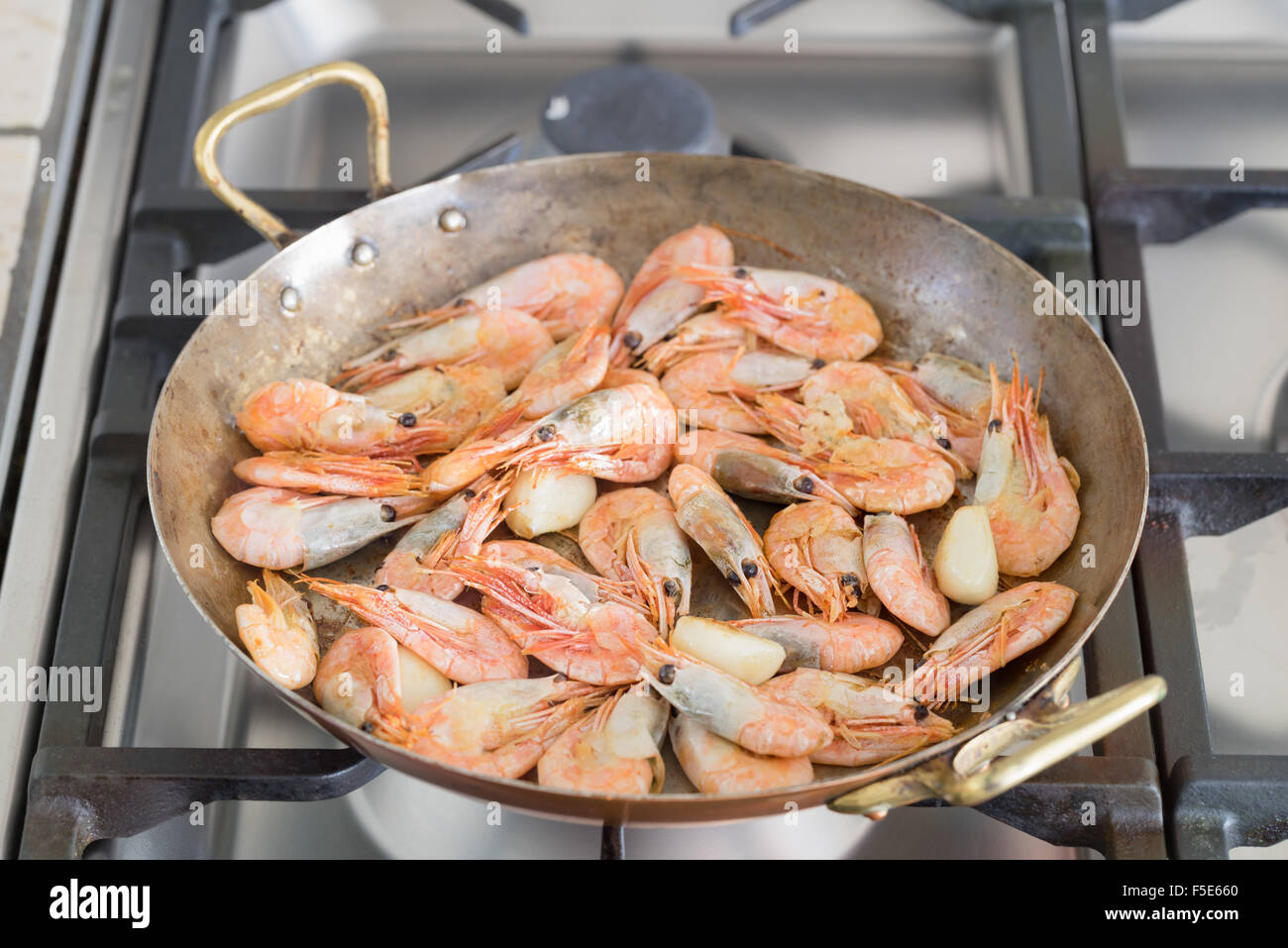 Prawns in a copper pan on a gas stove Stock Photo - Alamy